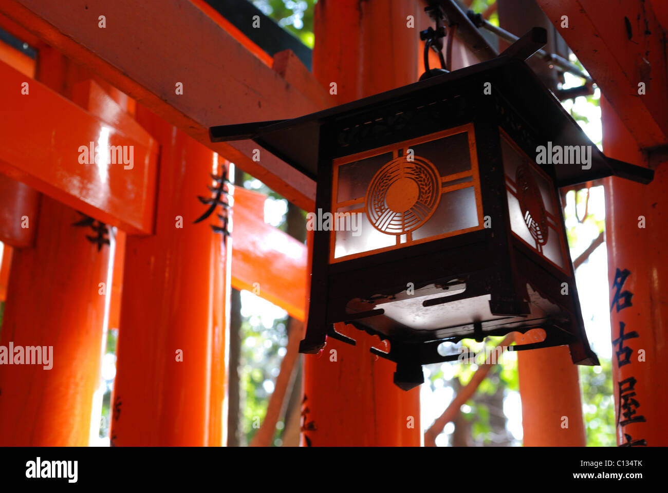 Close-up of a traditional lantern and torii (gate) at Fushimi Inari ...