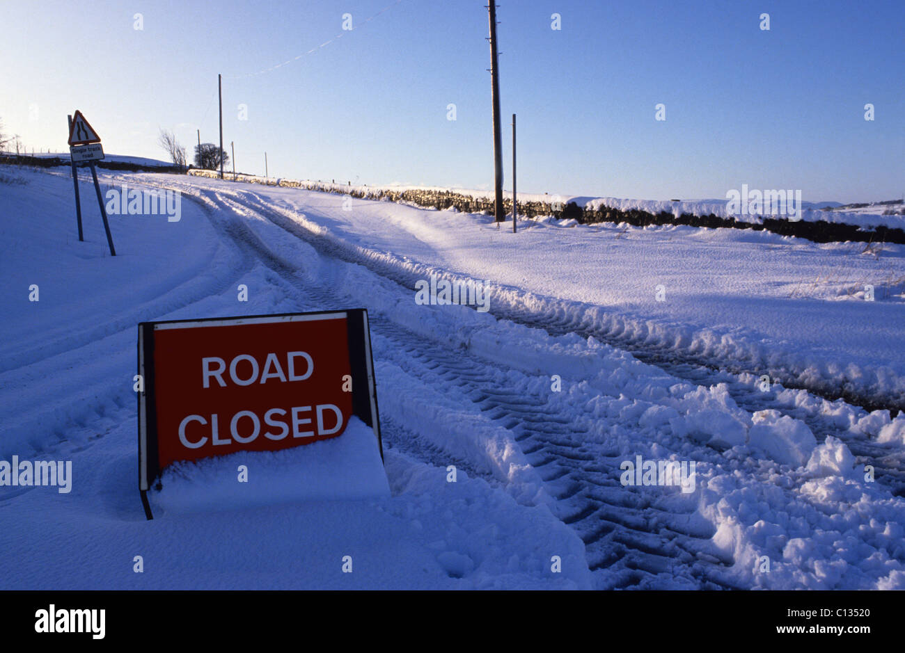 road closed sign on road blocked by deep winter snow at yeadon leeds ...