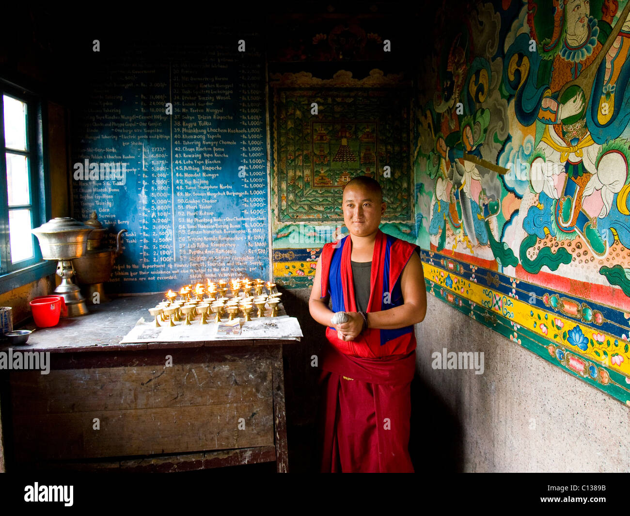 Buddhist monk lighting candles in a monastery Stock Photo - Alamy