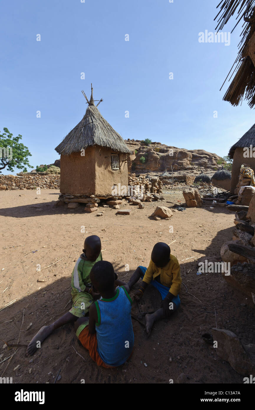 Children playing in a courtyard in front of a granary. Begnemato. Dogon ...