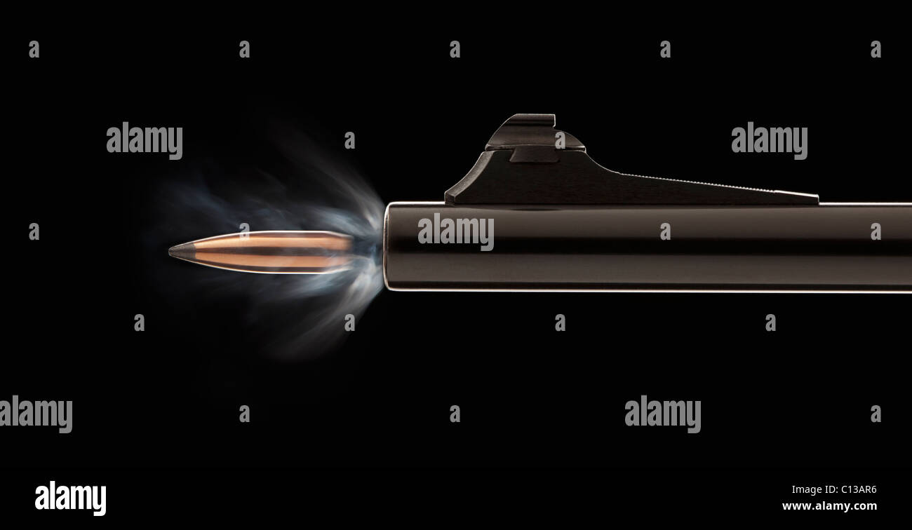 Studio shot of bullet coming out of gun barrel Stock Photo - Alamy