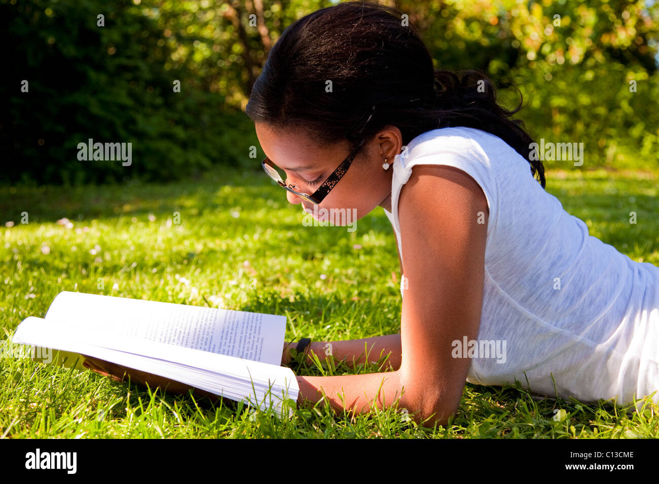 Young Student reading books at the school park Stock Photo - Alamy