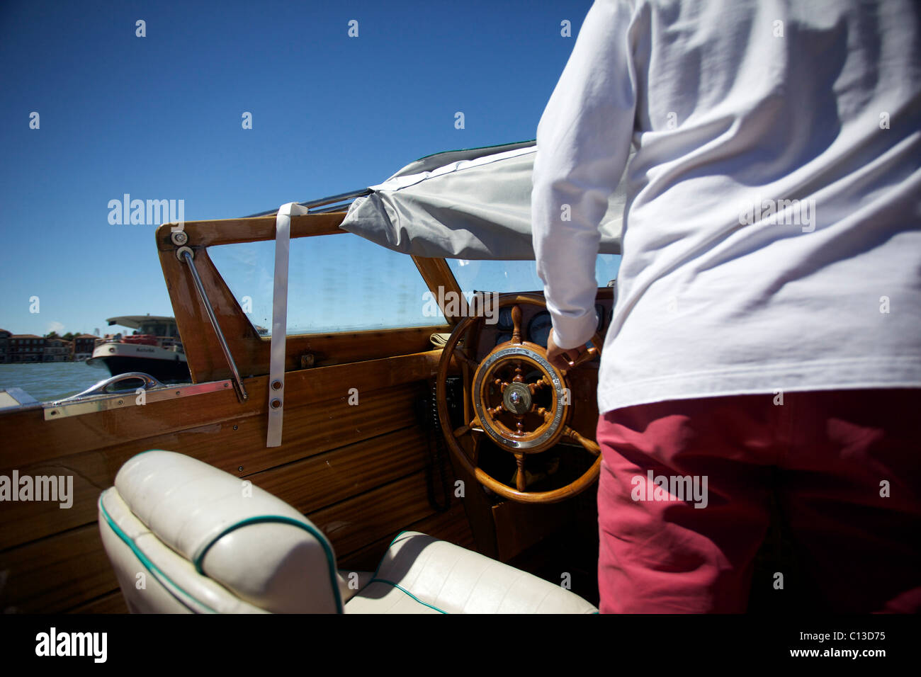 The hand of the pilot/driver of a private water taxi steers the boat in ...