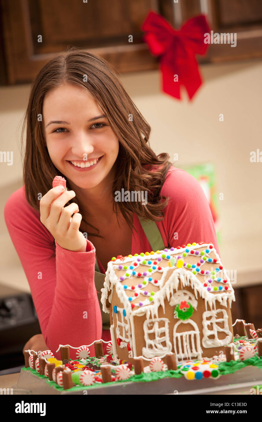 USA, Utah, Lehi, Portrait of young woman with gingerbread house in ...