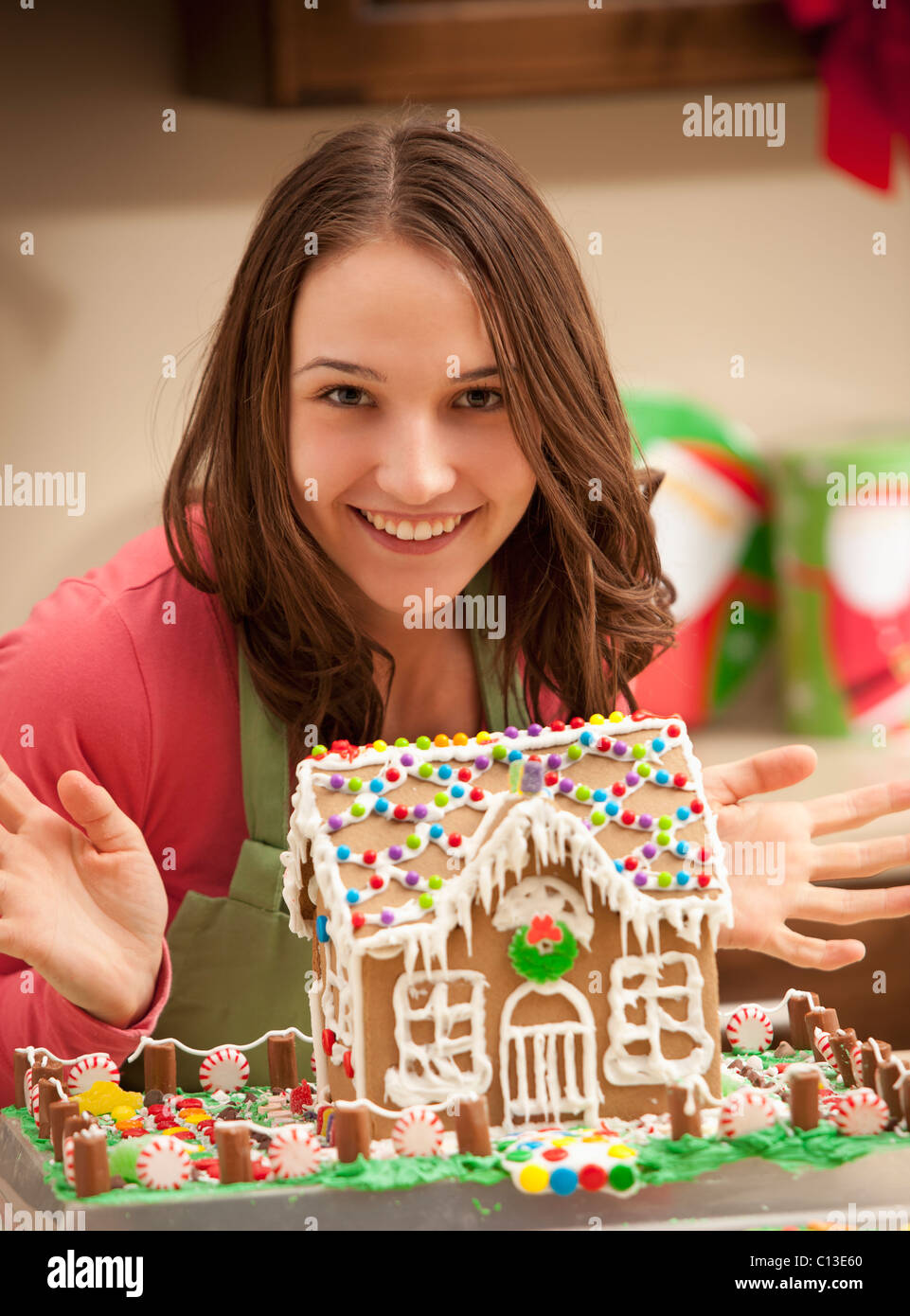 USA, Utah, Lehi, Portrait of young woman with gingerbread house in ...