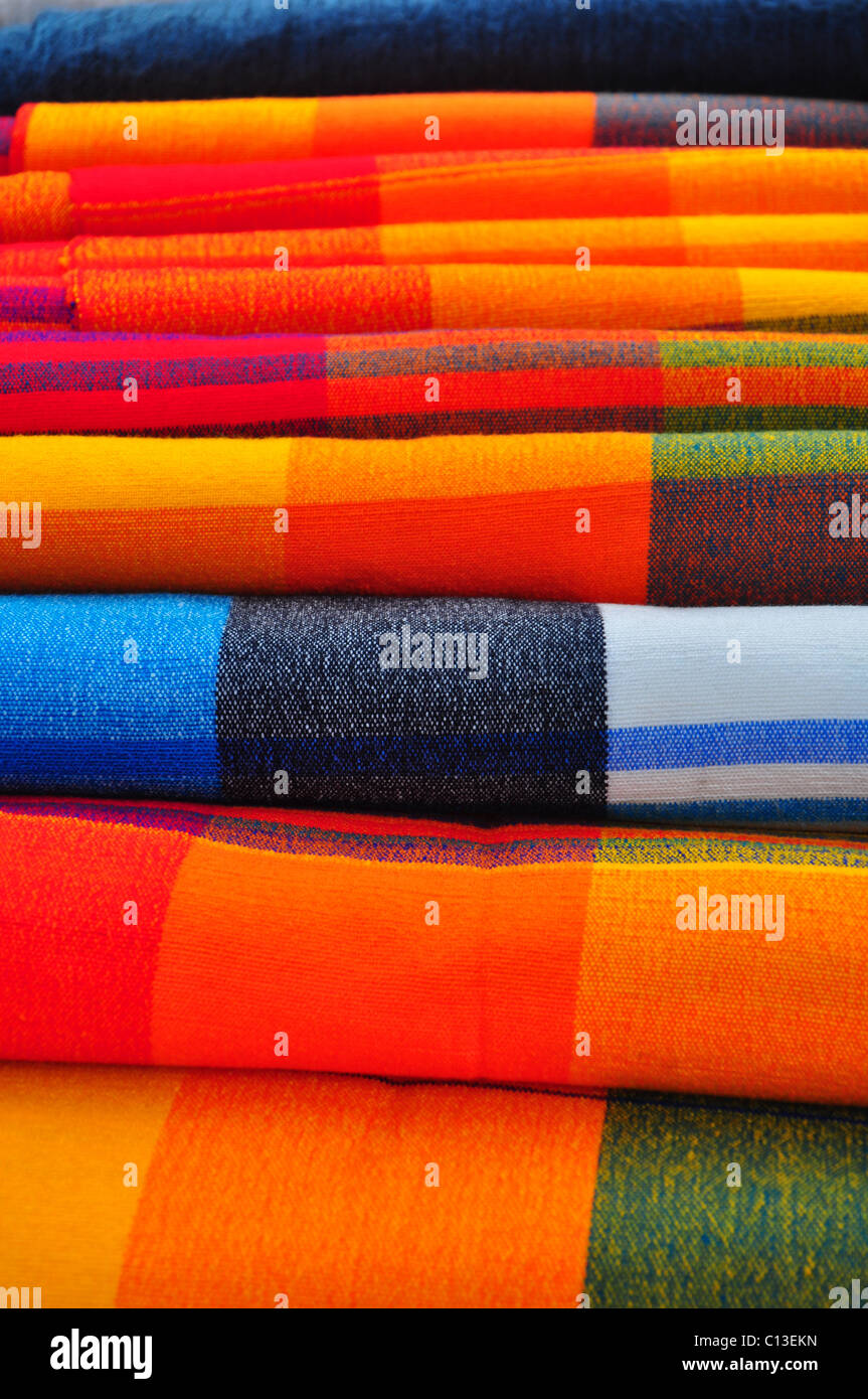 Collection of brightly coloured traditional blankets in craft market ...