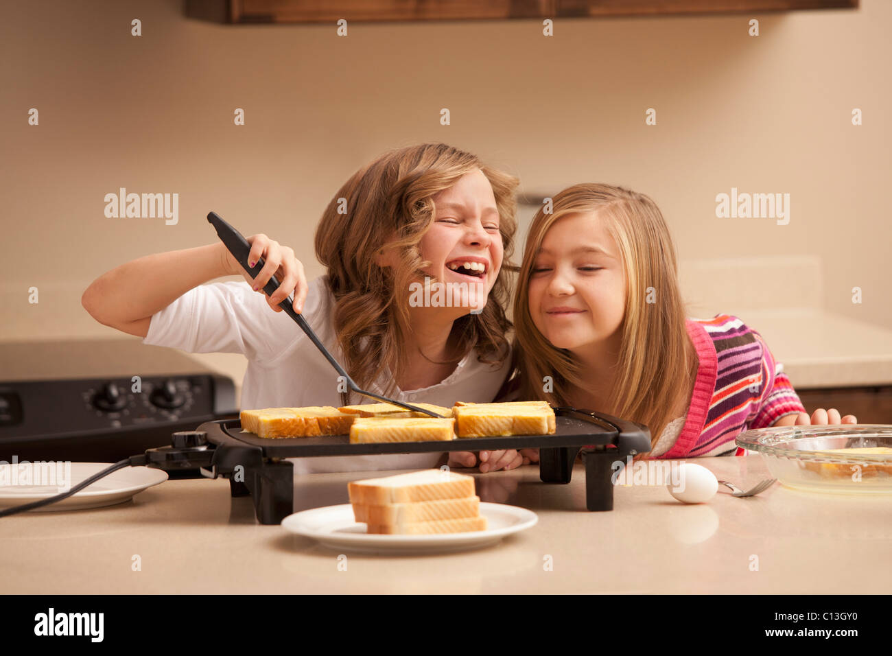 USA, Utah, Lehi, Two girls (10-11) preparing toast in kitchen Stock ...