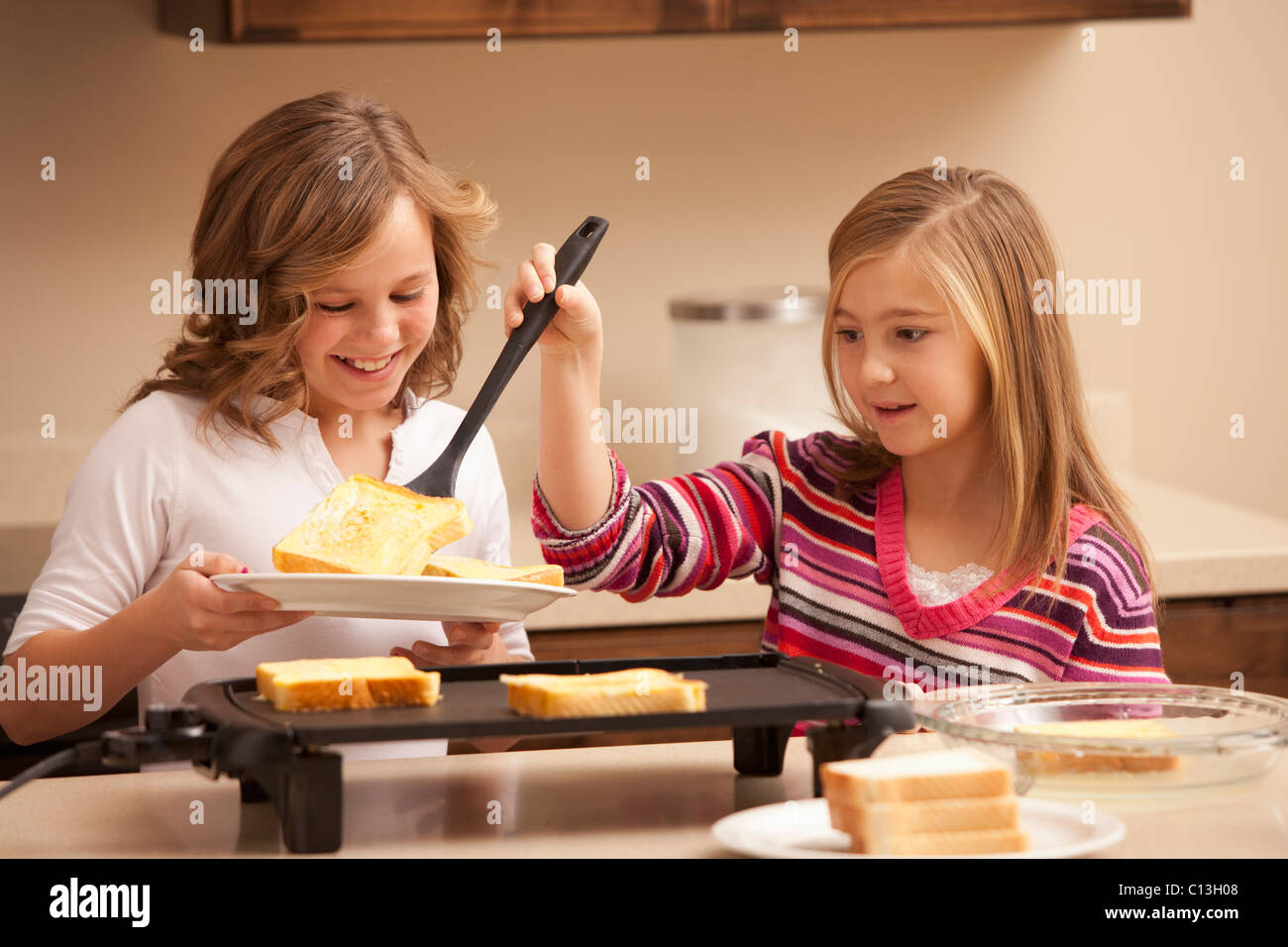 USA, Utah, Lehi, Two girls (10-11) preparing toast in kitchen Stock ...