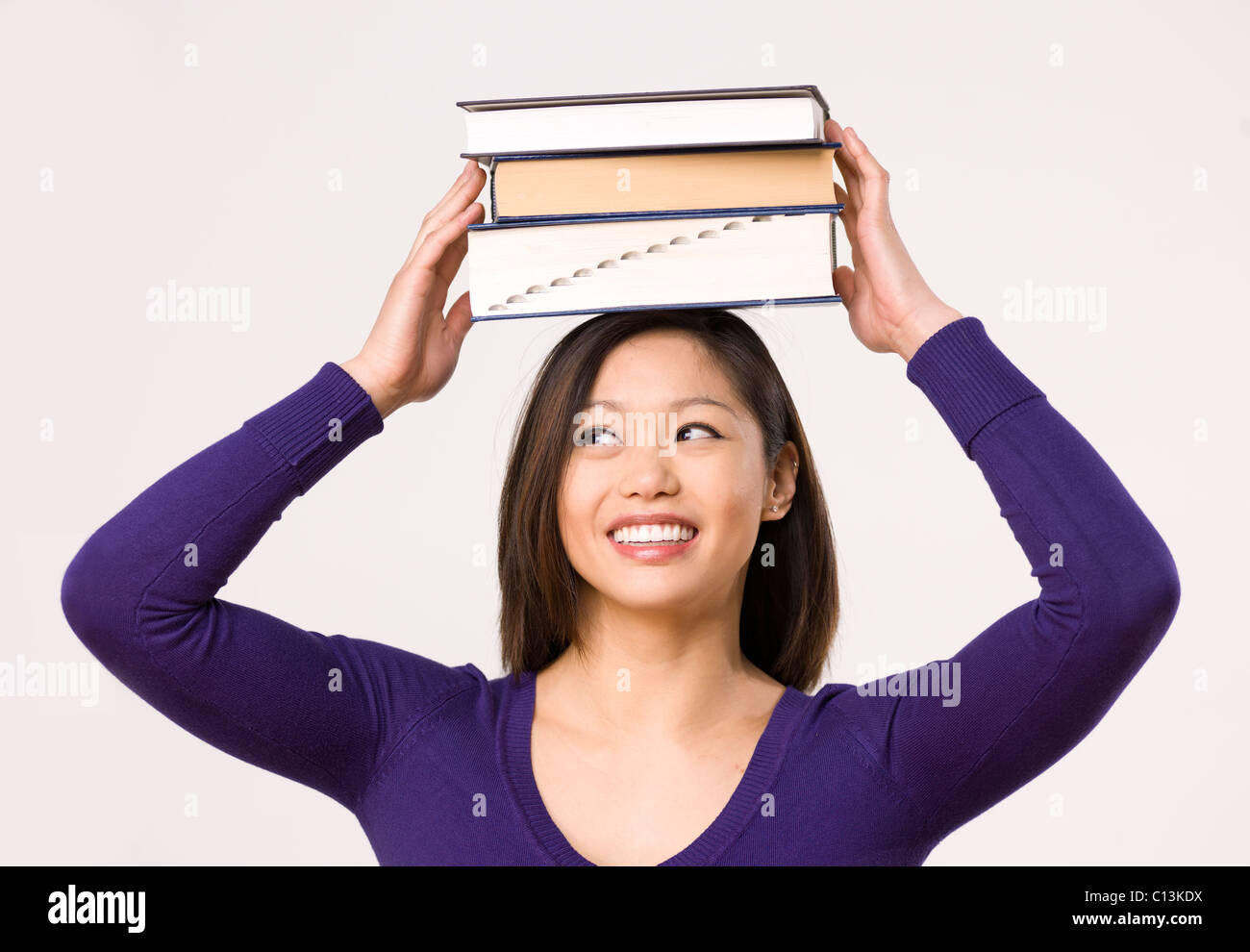Female student carrying book on head Stock Photo - Alamy