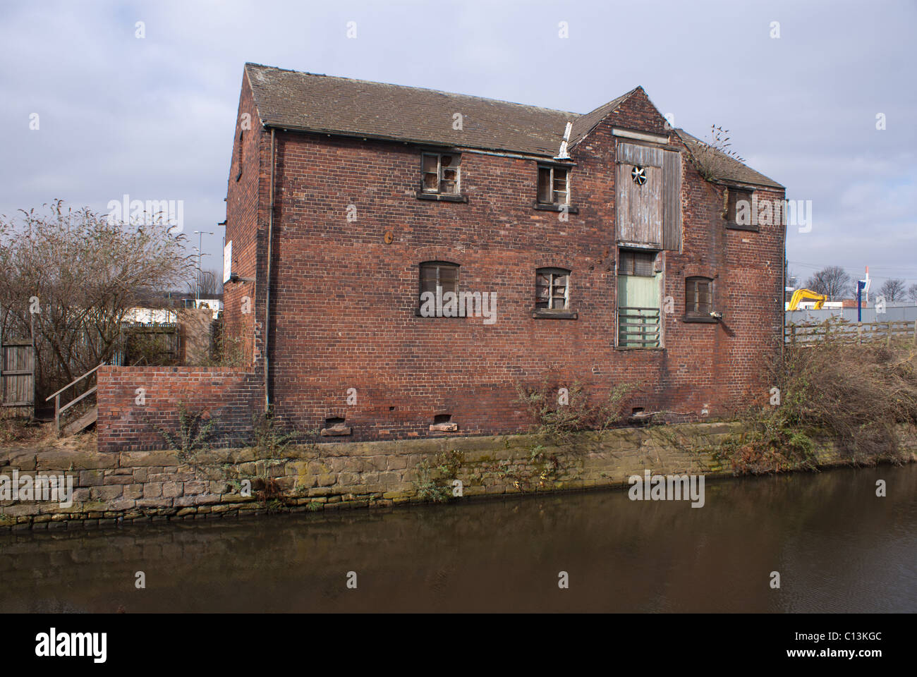 Empty building at the side of a canal Stock Photo - Alamy