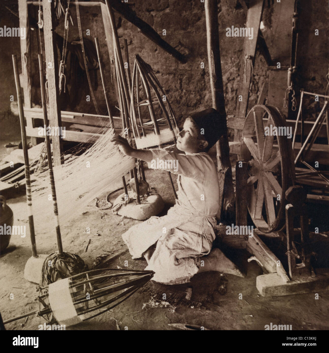 Young boy unwinding silk cocoons and reeling silk threads with pre ...