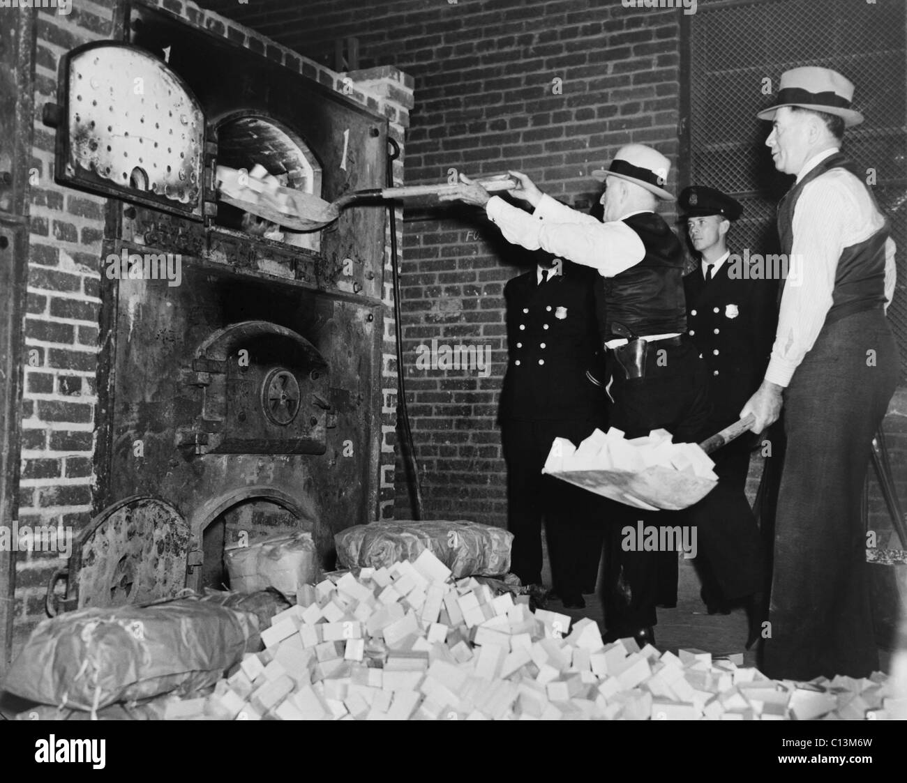 Federal Bureau of Narcotics agents shovel confiscated heroin blocks ...