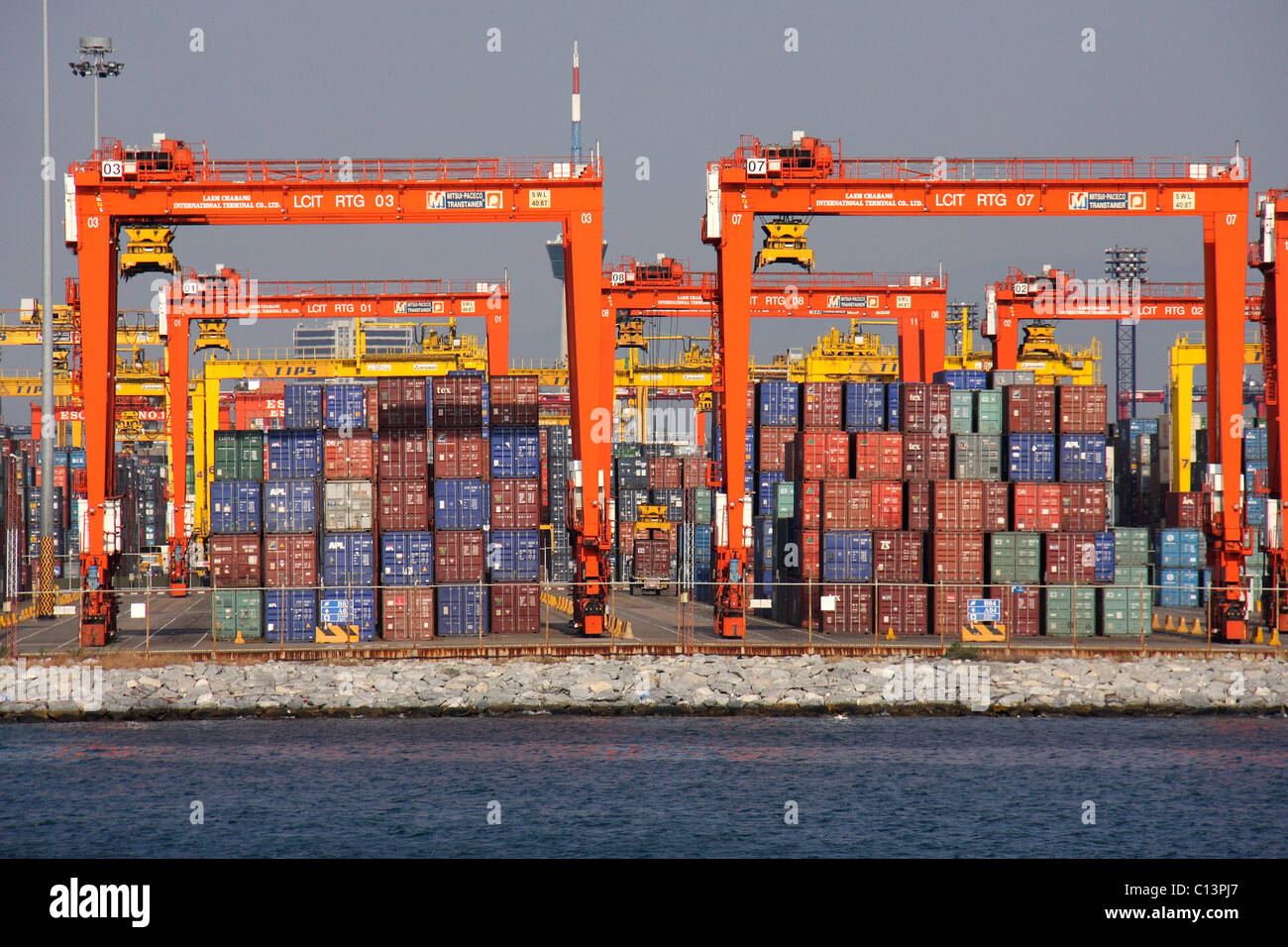 a stack of shipping cargo containers and cranes in a container terminal ...