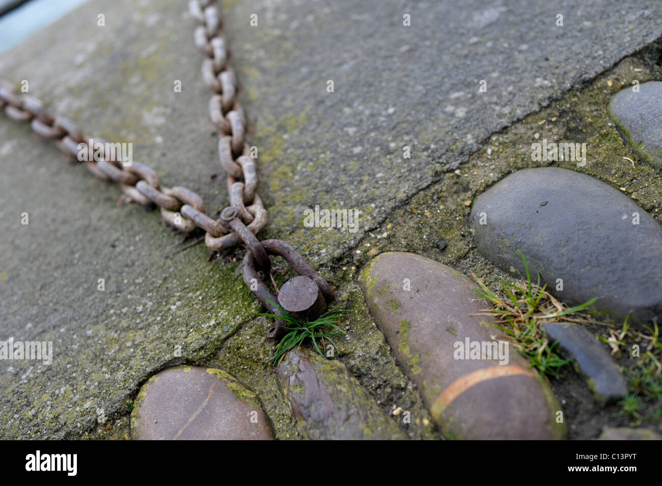 Iron chain fixed in quayside by cobblestones for boat moorings at ...