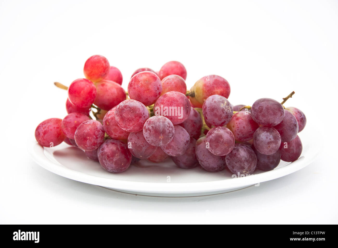 Fresh red grapes on white background Stock Photo - Alamy