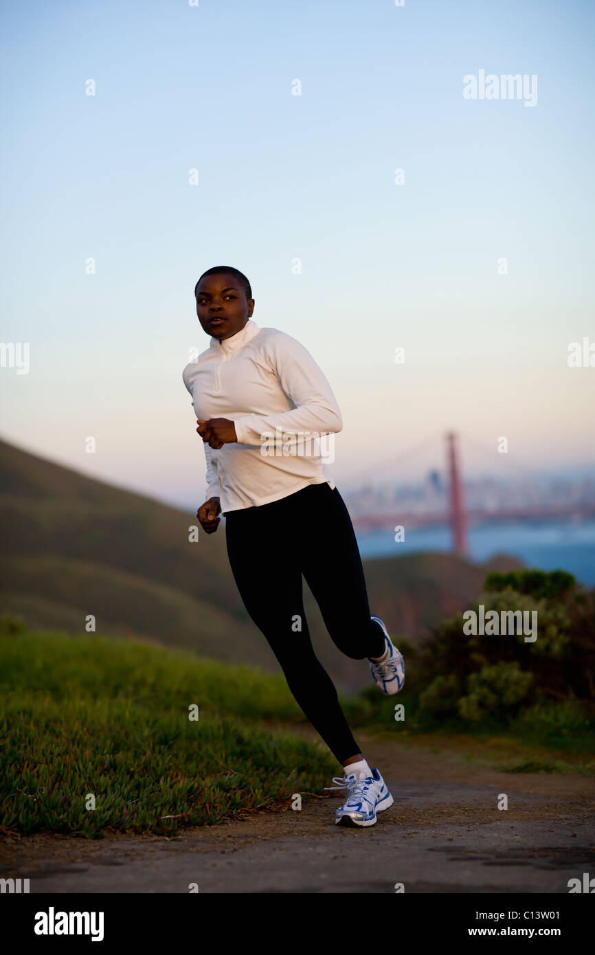 USA, California, San Francisco, Woman jogging, Golden Gate Bridge in ...