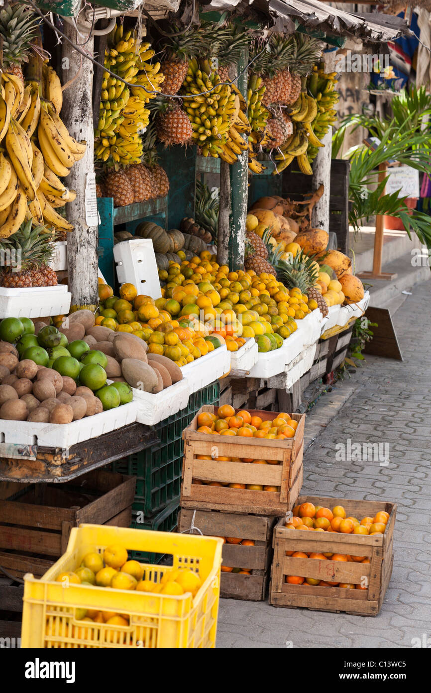 Open air fruit market in Tulum. Ripe fruit spills out onto the sidewalk ...