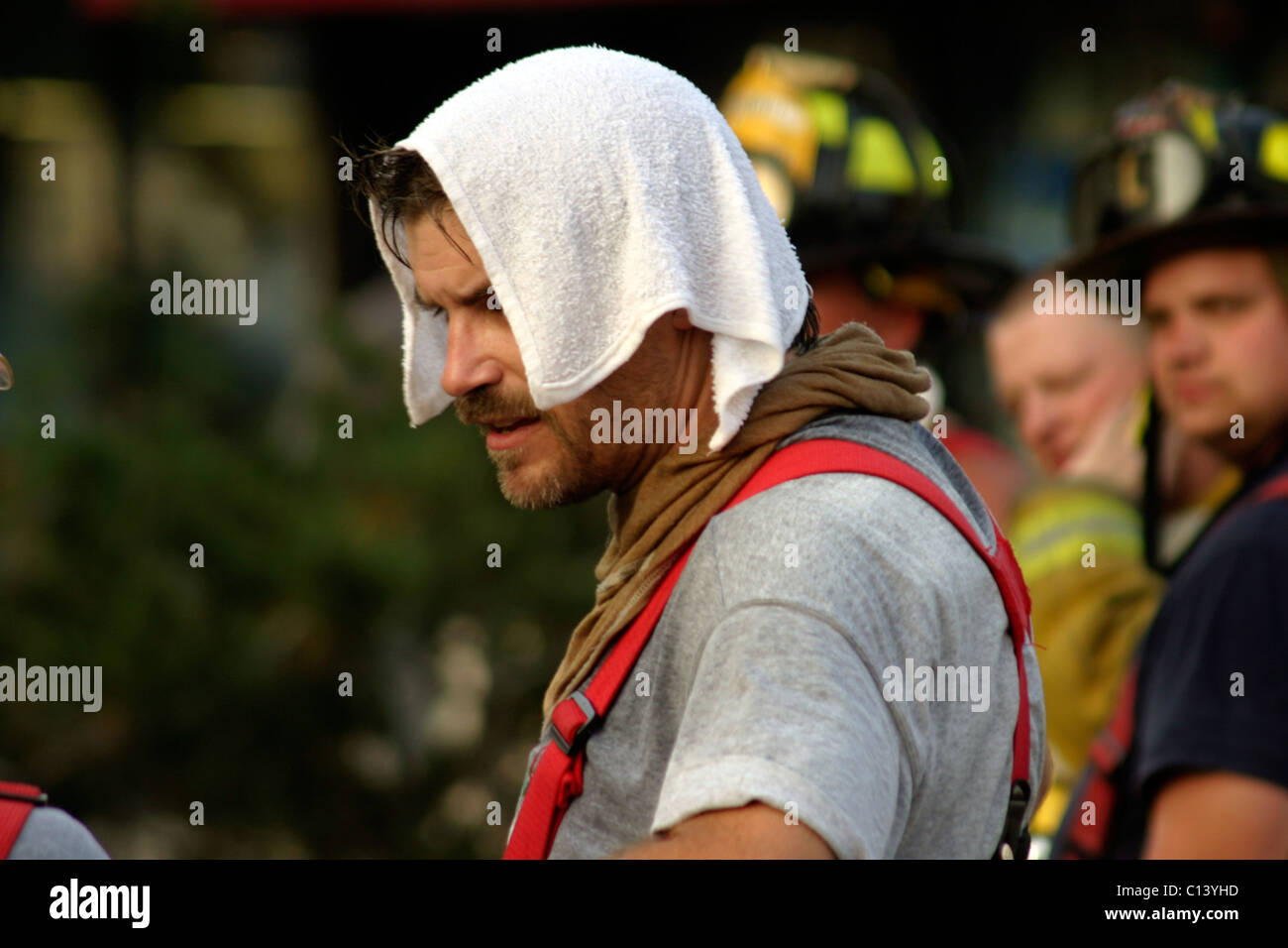Firefighter uses cold towel to cool down at scene of a fire Stock Photo ...