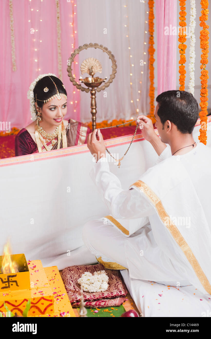 Bridegroom putting Mangal Sutra to a bride at the South Indian wedding ...