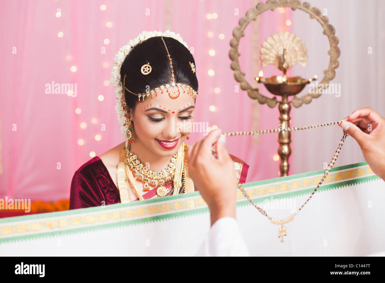 Bridegroom putting Mangal Sutra to a bride at the South Indian wedding ...