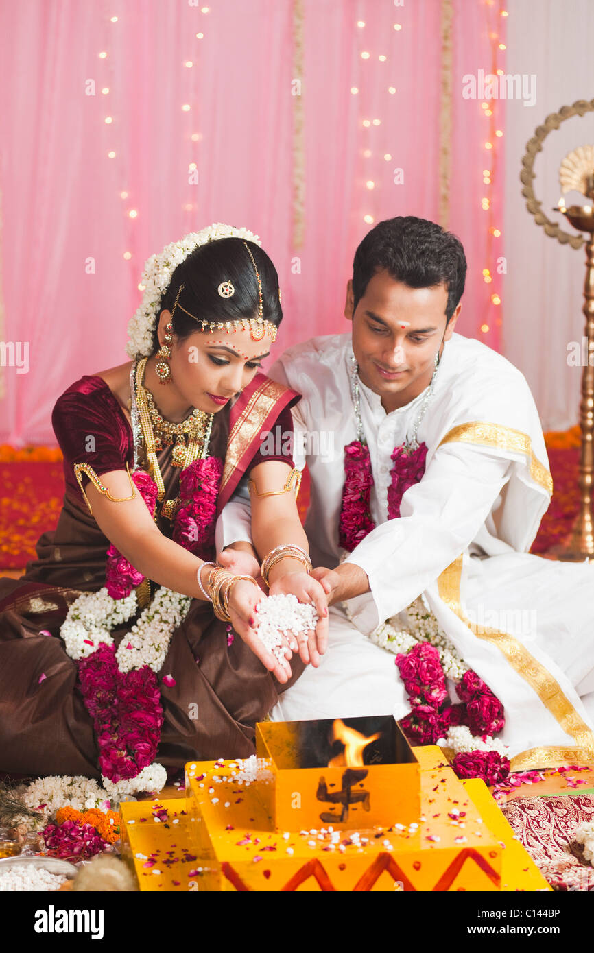 Bride and bridegroom performing a religious ceremony during south ...