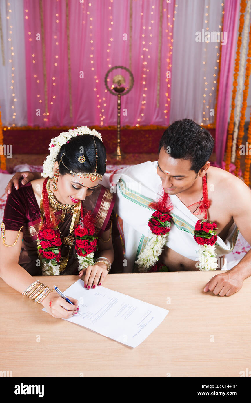 Newlywed couple signing a marriage certificate Stock Photo - Alamy