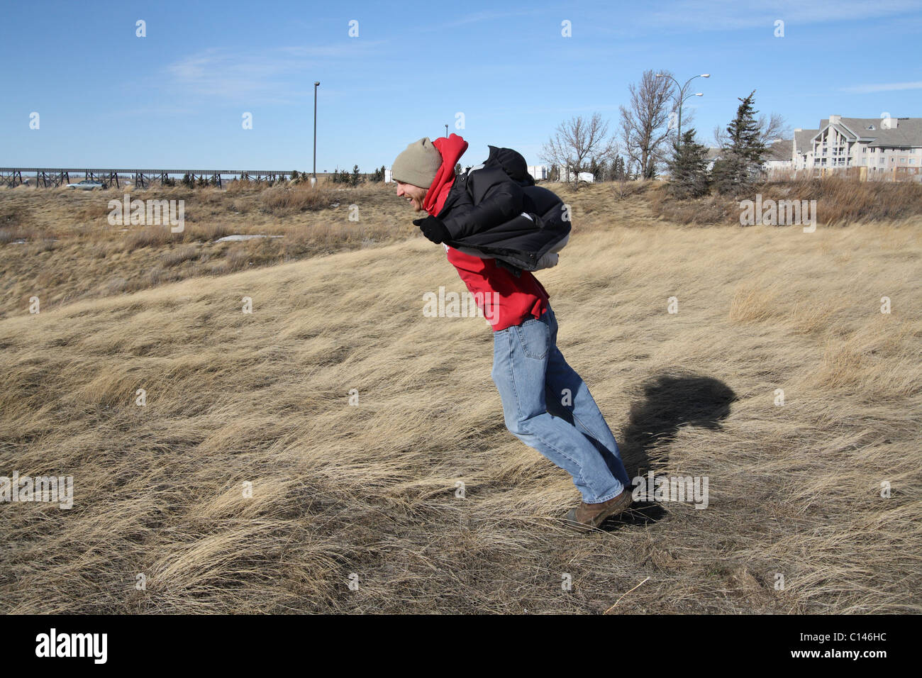 A man leaning into a strong wind Stock Photo - Alamy