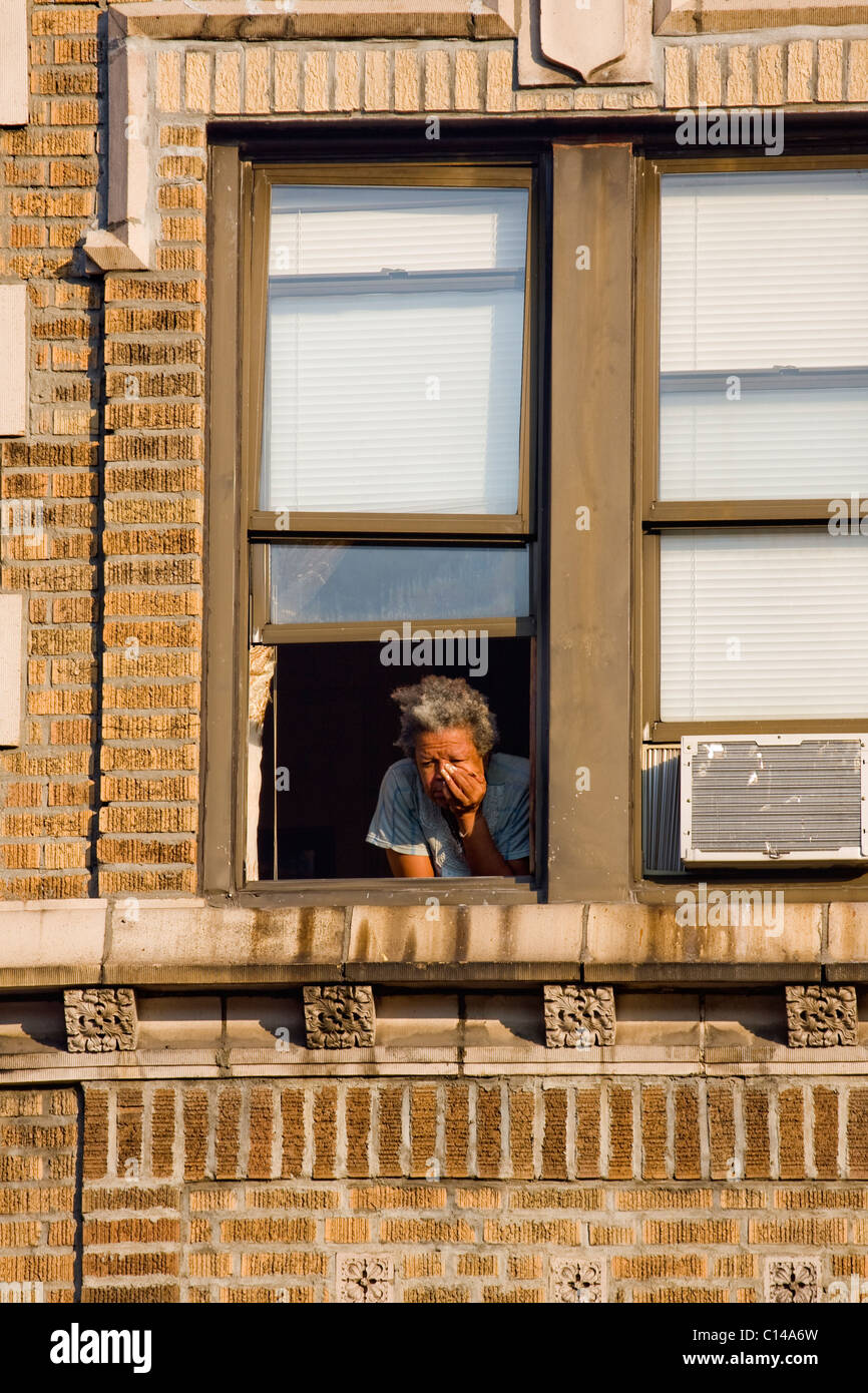 African American Woman looking out apartment window in New York City ...