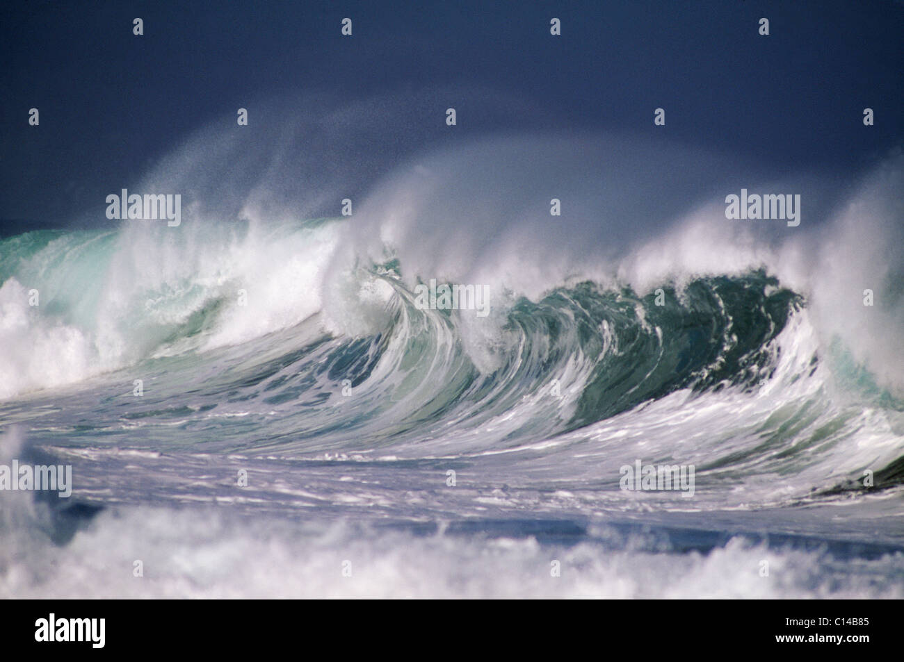 large offshore waves break on the beach set against a stormy sky Stock ...