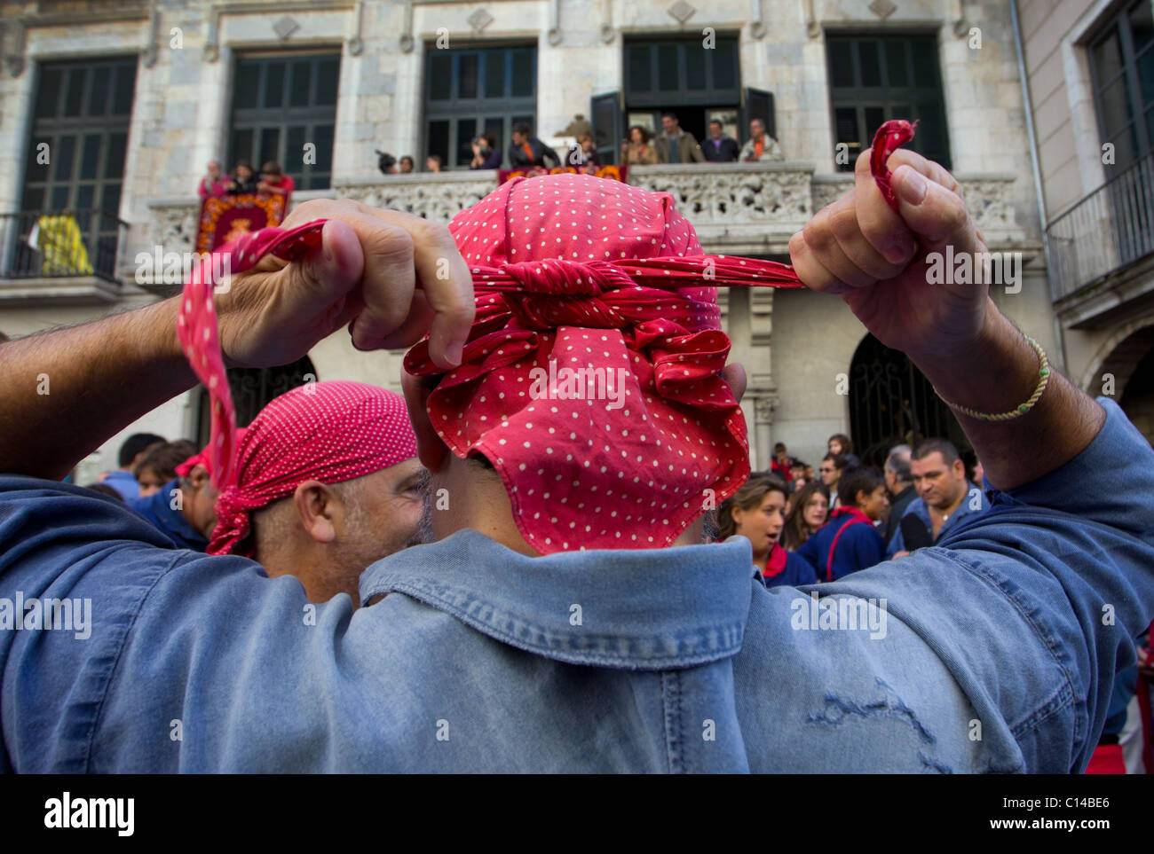 Participant in human tower festival in Catalonia, Spain tying bandana ...