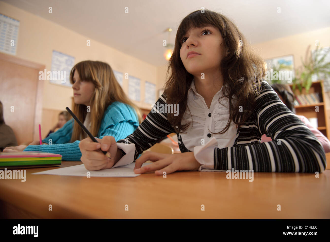 Attentive schoolgirl is listening to her teacher during lesson Stock ...
