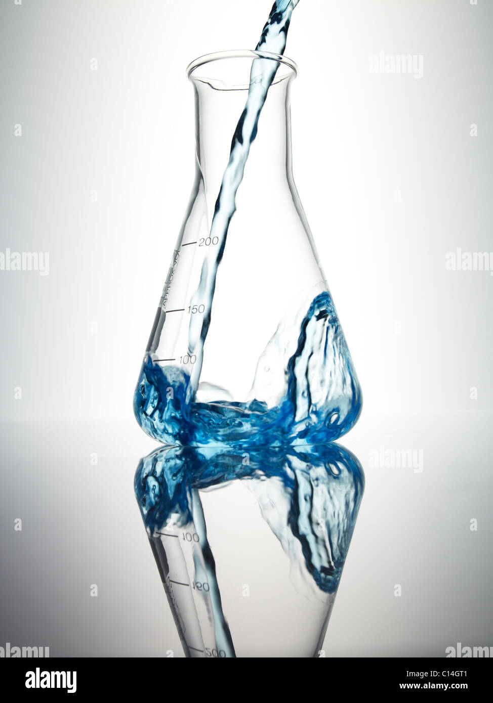 Science lab flask on a white background the flask contains a clear blue ...