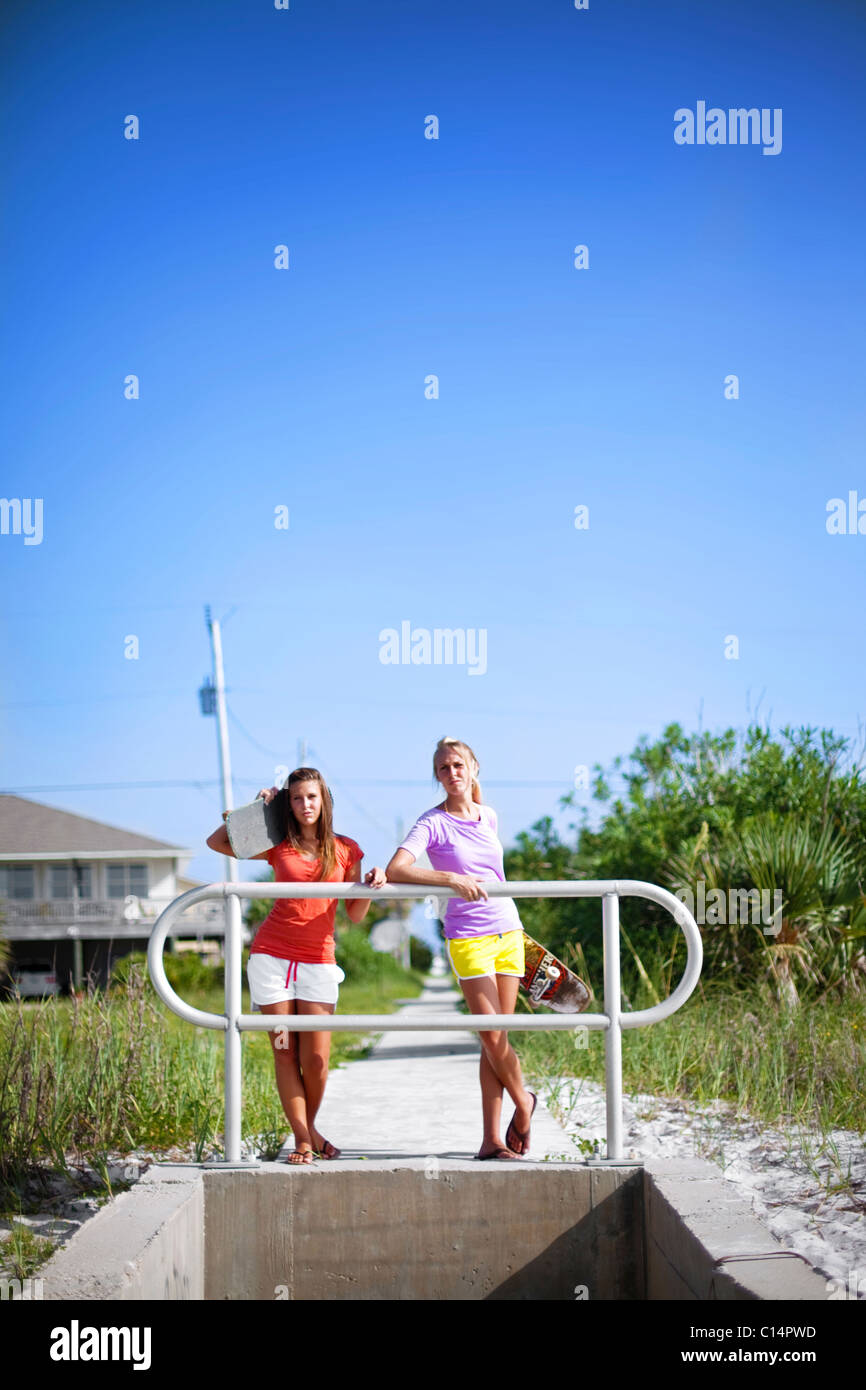 Two girls rest with their skateboards as they look out over the Santa ...