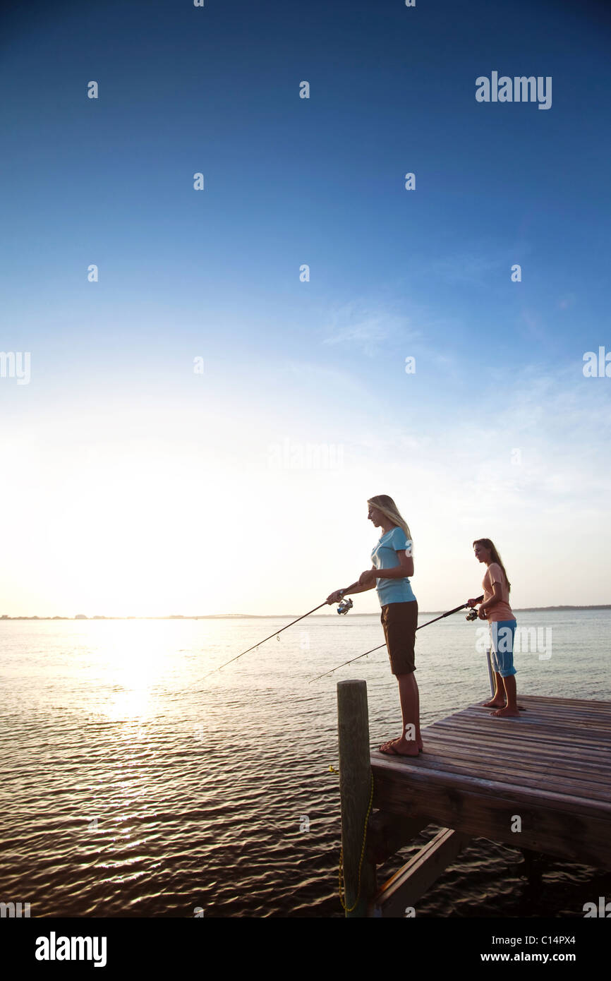 Two girls fish off a pier on the Santa Rosa Sound, Pensacola Beach ...