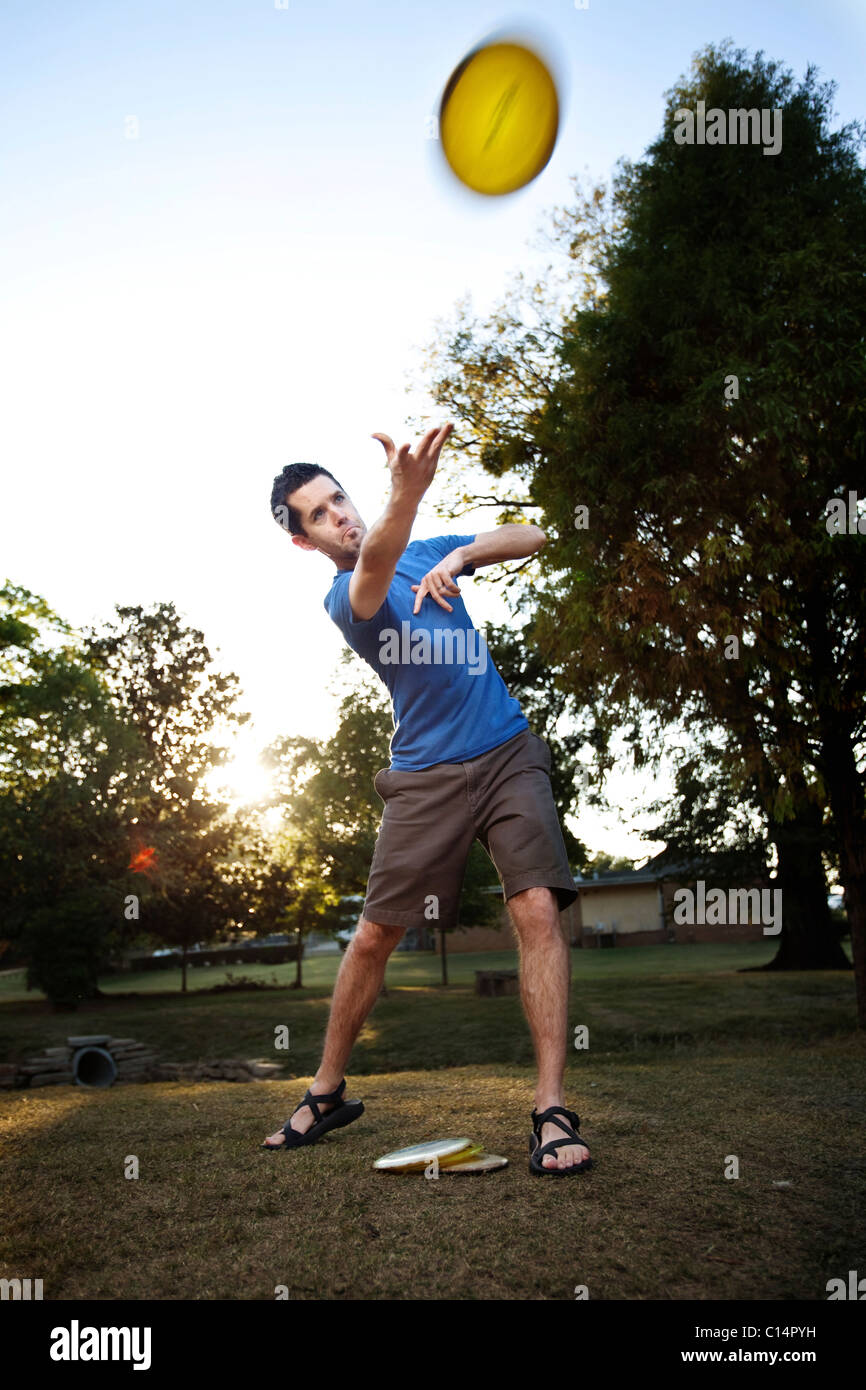 A man makes a forehanded drive playing disc golf. (Back Lit, Motion ...