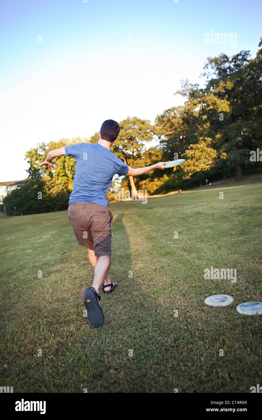 A man makes a forehanded throw playing disc golf Stock Photo - Alamy