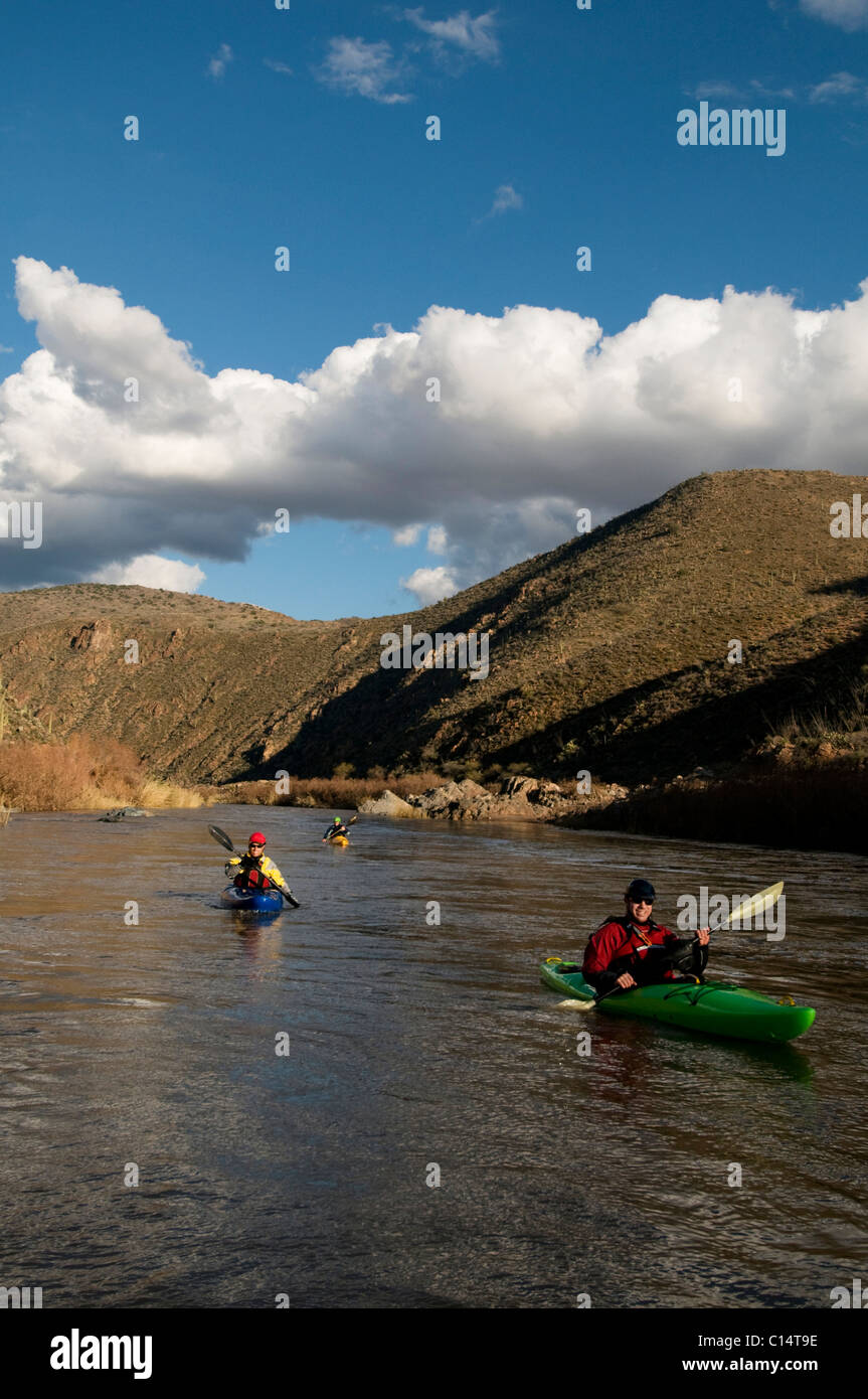 Whitewater kayakers paddle downstream during a whitewater rafting trip ...
