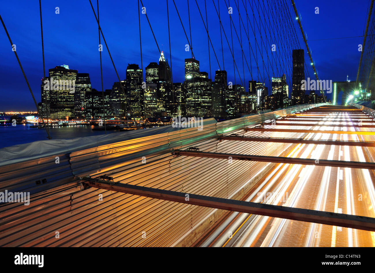 Cars pass over the Brooklyn Bridge with the New York City skyline in ...