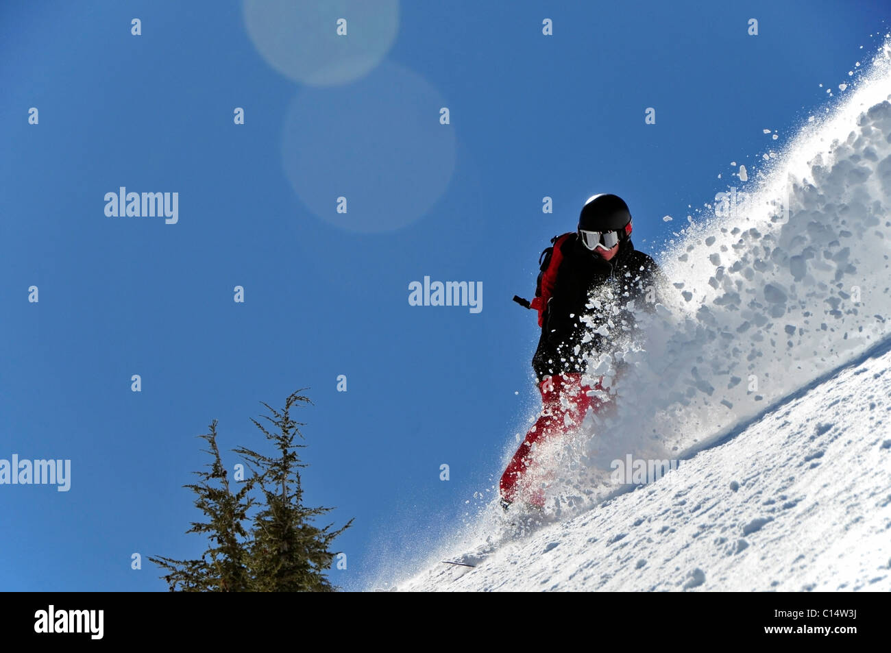 A male snowboarder makes a big powder turn in the Kirkwood backcountry ...