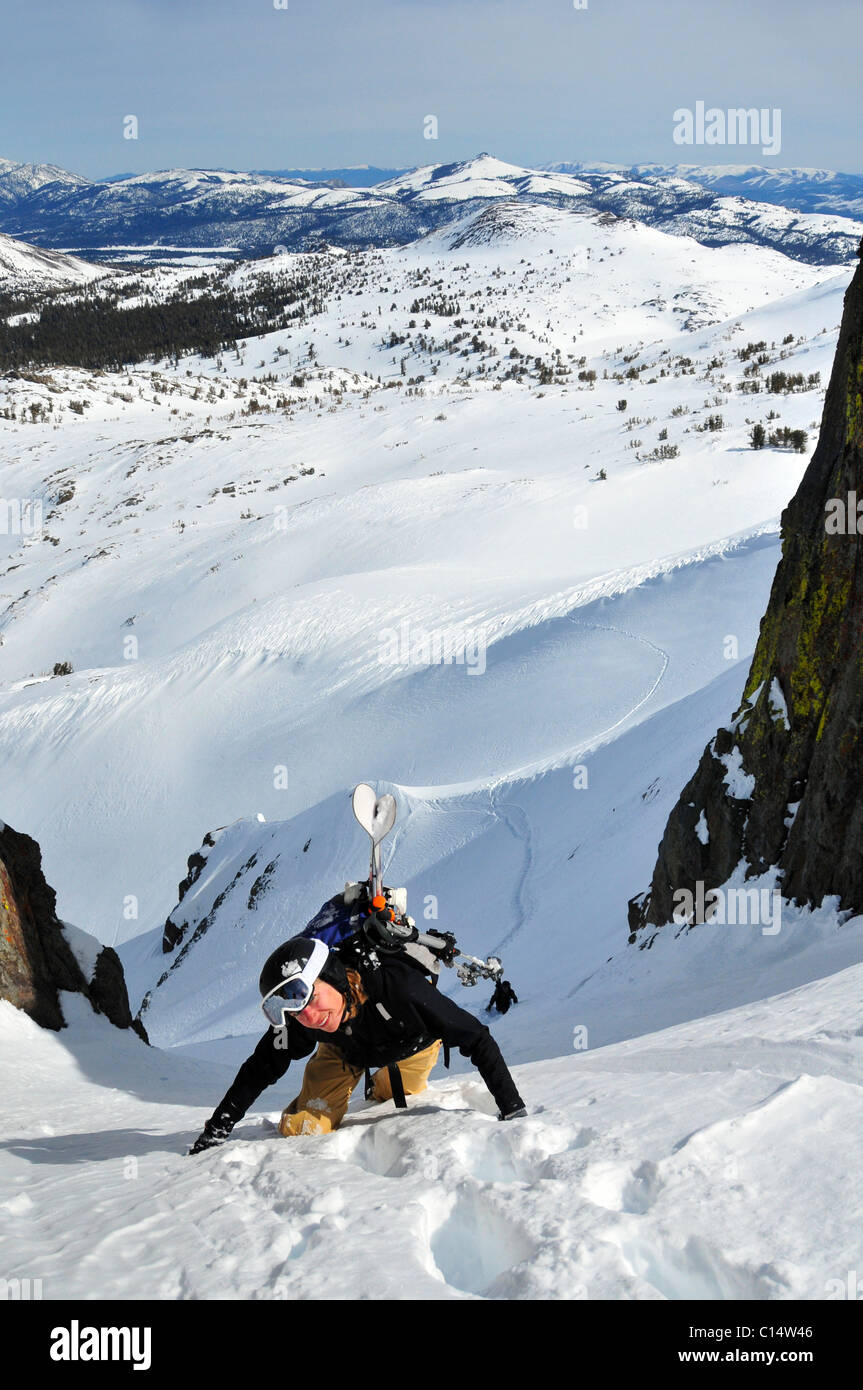 A female skier climbs up a steep couloir in the winter near Carson Pass ...