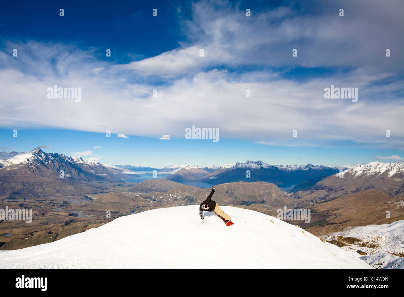 A male snowboarder blasts a heel side turn while snowboarding in ...