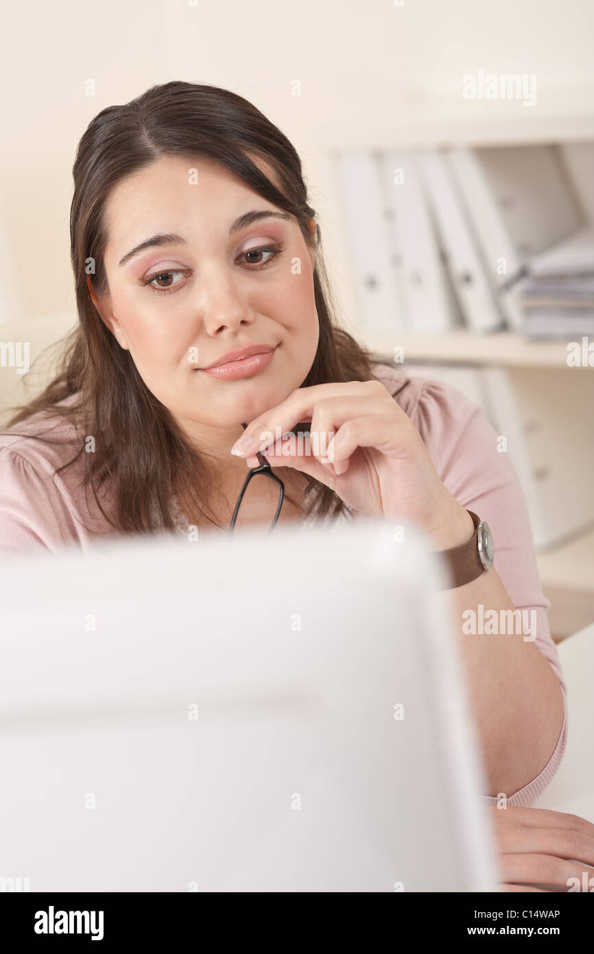 Young businesswoman watching computer screen at office, thinking Stock ...