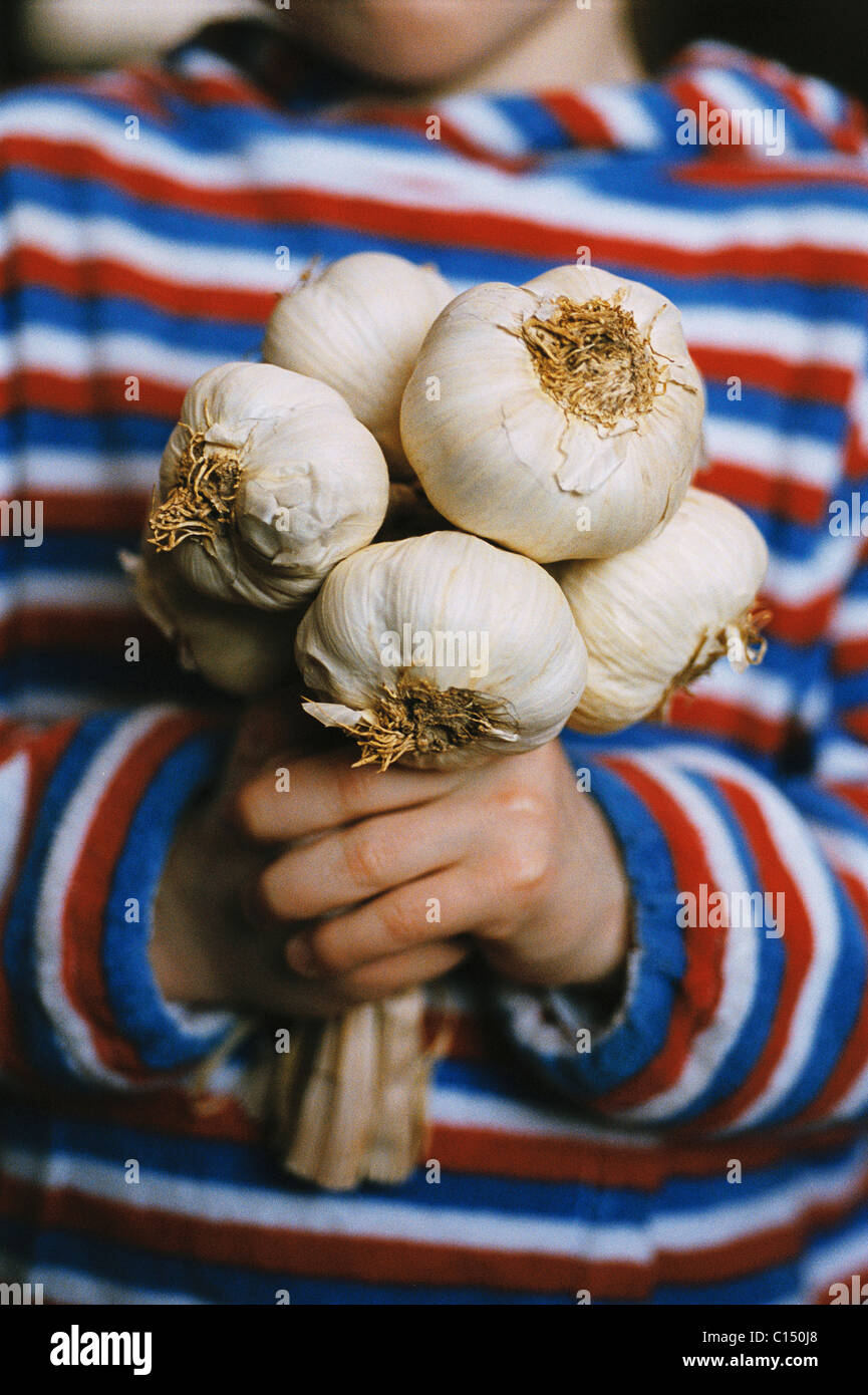 5 year old boy holding a bunch of garlic Stock Photo - Alamy