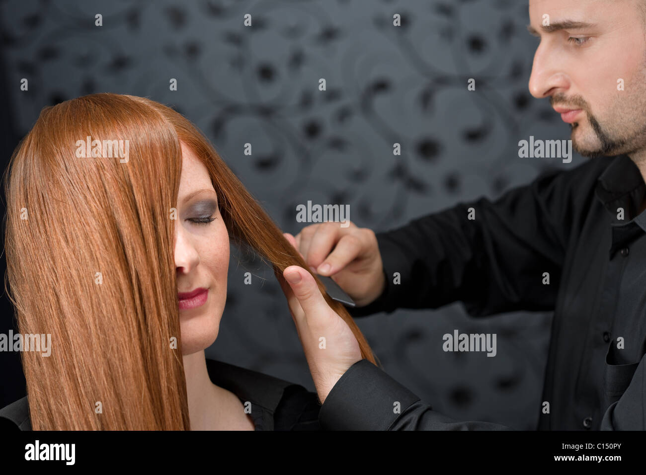 Professional hairdresser with long red hair fashion model at luxury ...