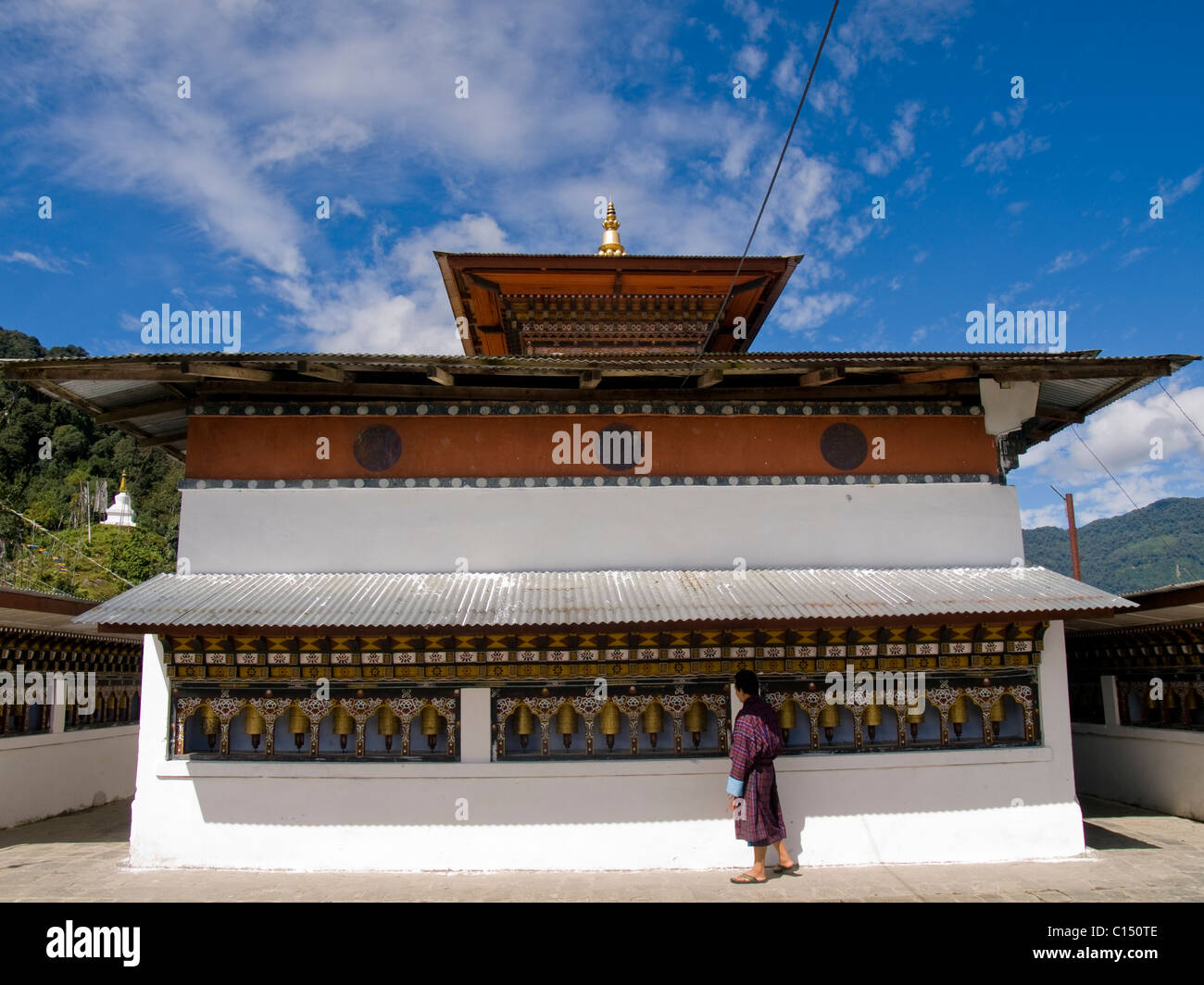 Man turning the prayer wheels on the outside of a temple Stock Photo ...