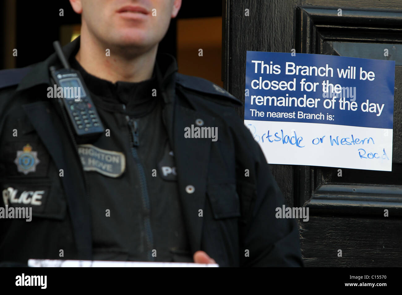 A Brighton And Hove Police Officer Stands Guard Outside A Natwest Bank