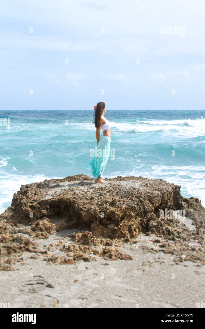 Yoga on the beach with rocks Stock Photo - Alamy