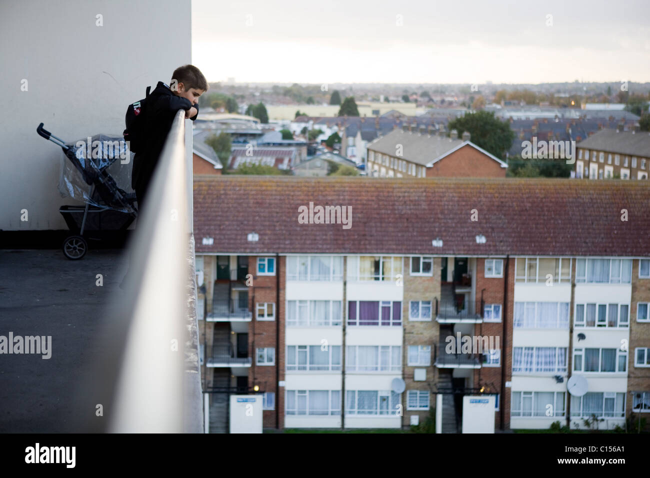 Boy looking over balcony on housing estate in East London Stock Photo ...