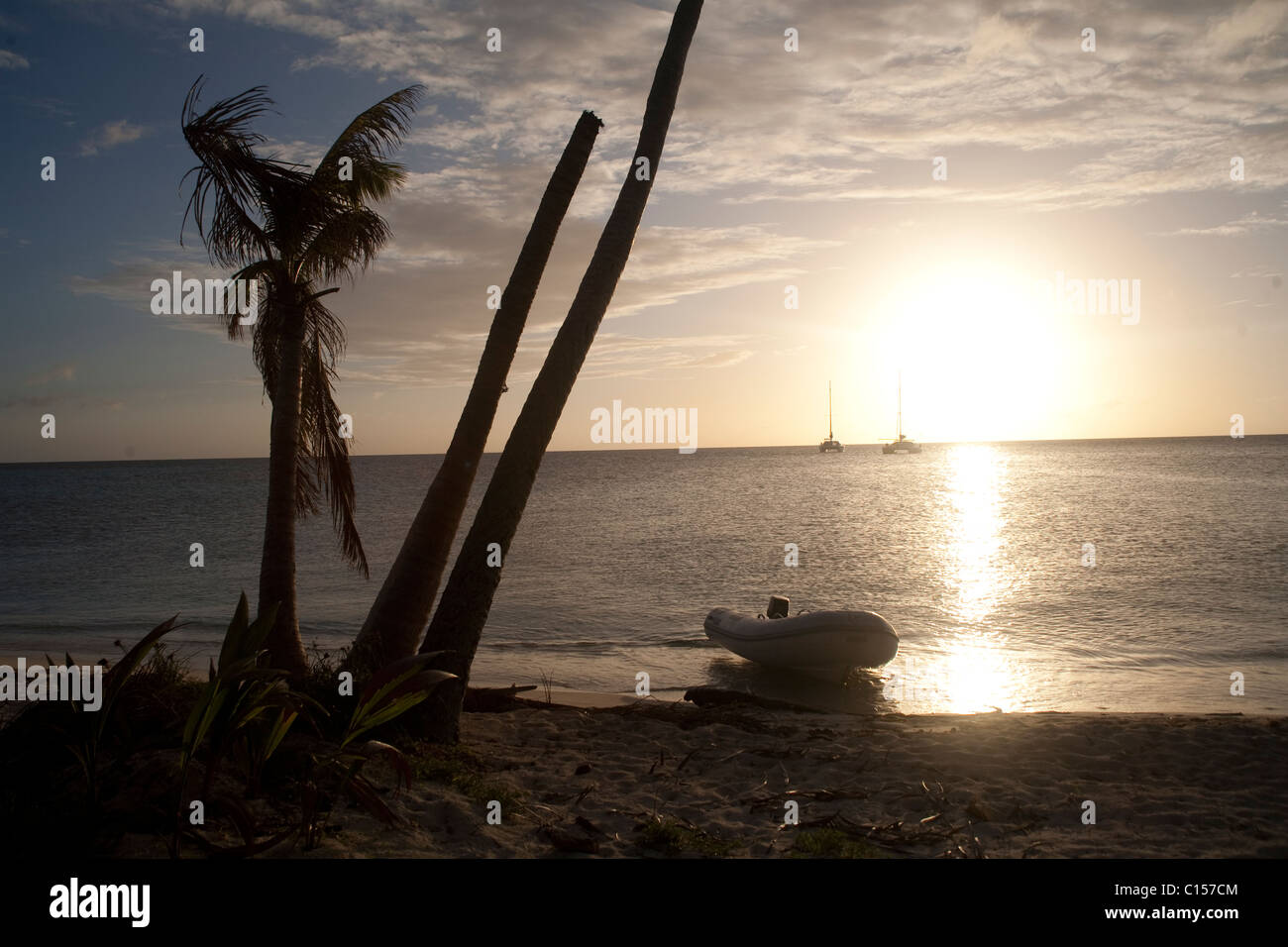 tropical island with dingy and sail boats in distance Stock Photo - Alamy