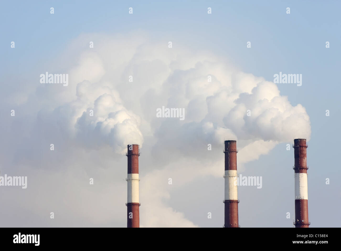Three smoking chimneys other blue sky Stock Photo - Alamy